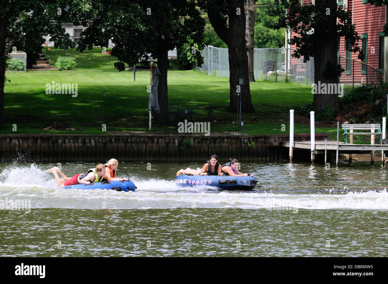 Teenagers tubbing on a river Stock Photo - Alamy