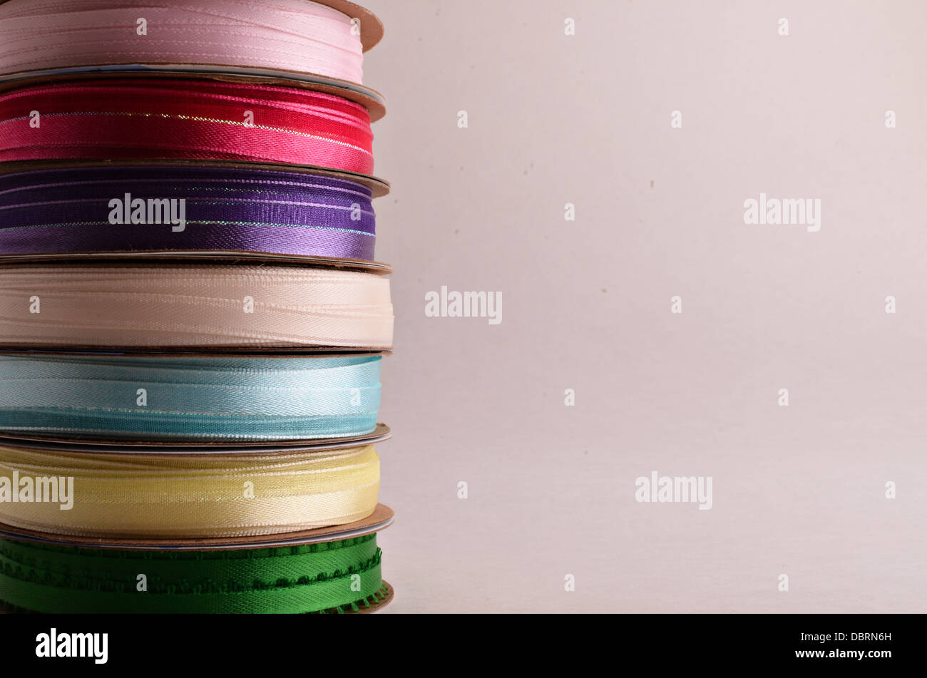 A stack of spools of ribbon on a white background Stock Photo - Alamy
