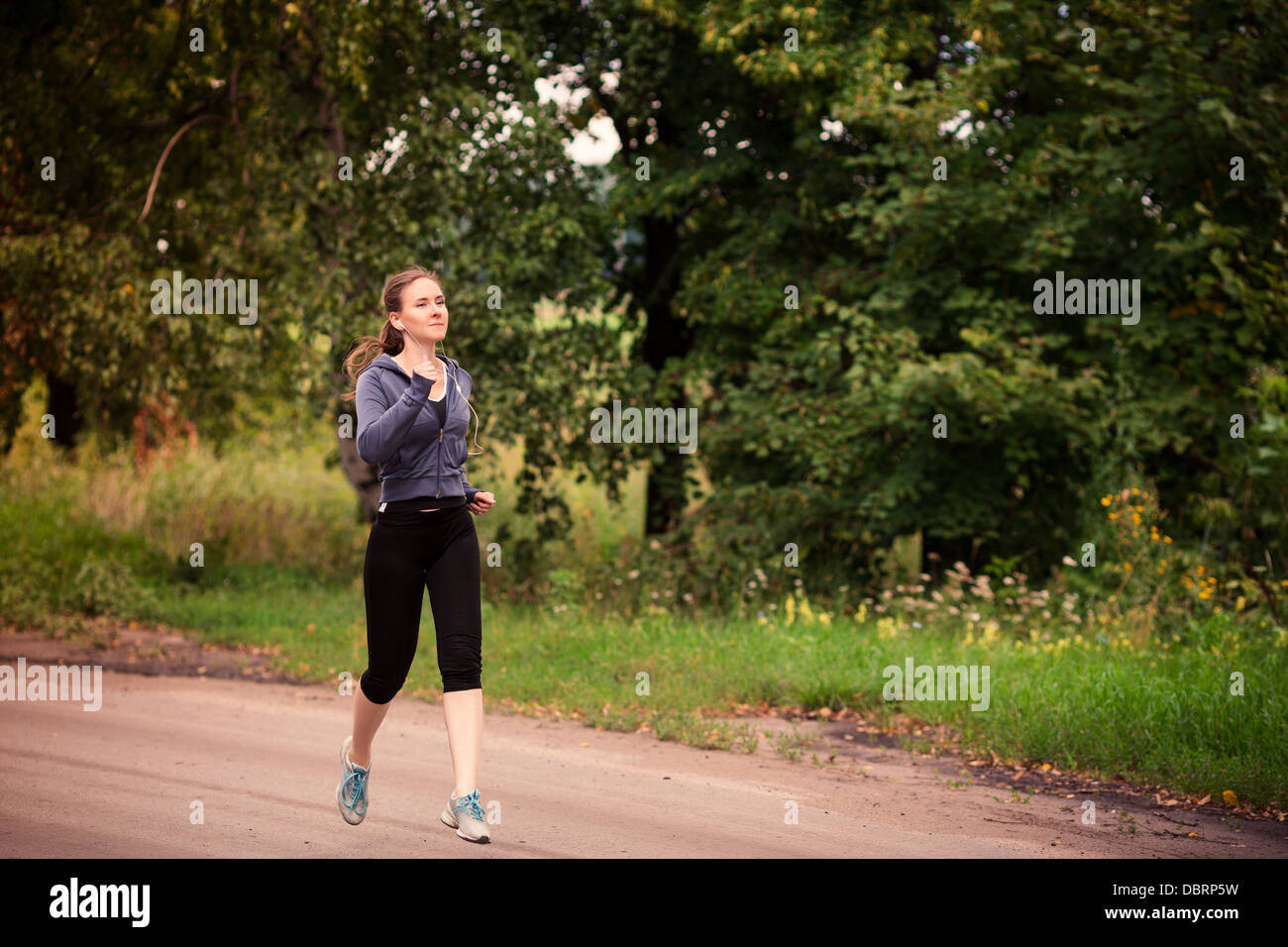Beautiful fit runner woman jogging in nature outdoor Stock Photo - Alamy