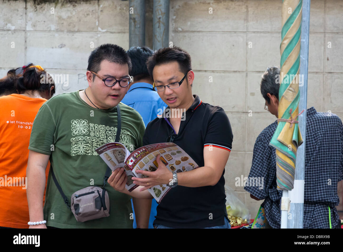Men reading a Brochure in Bangkok, Thailand Stock Photo - Alamy
