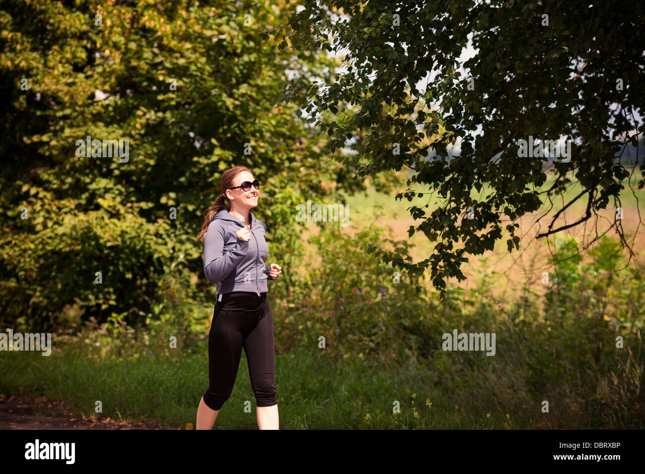 Beautiful fit runner woman jogging in nature outdoor Stock Photo - Alamy