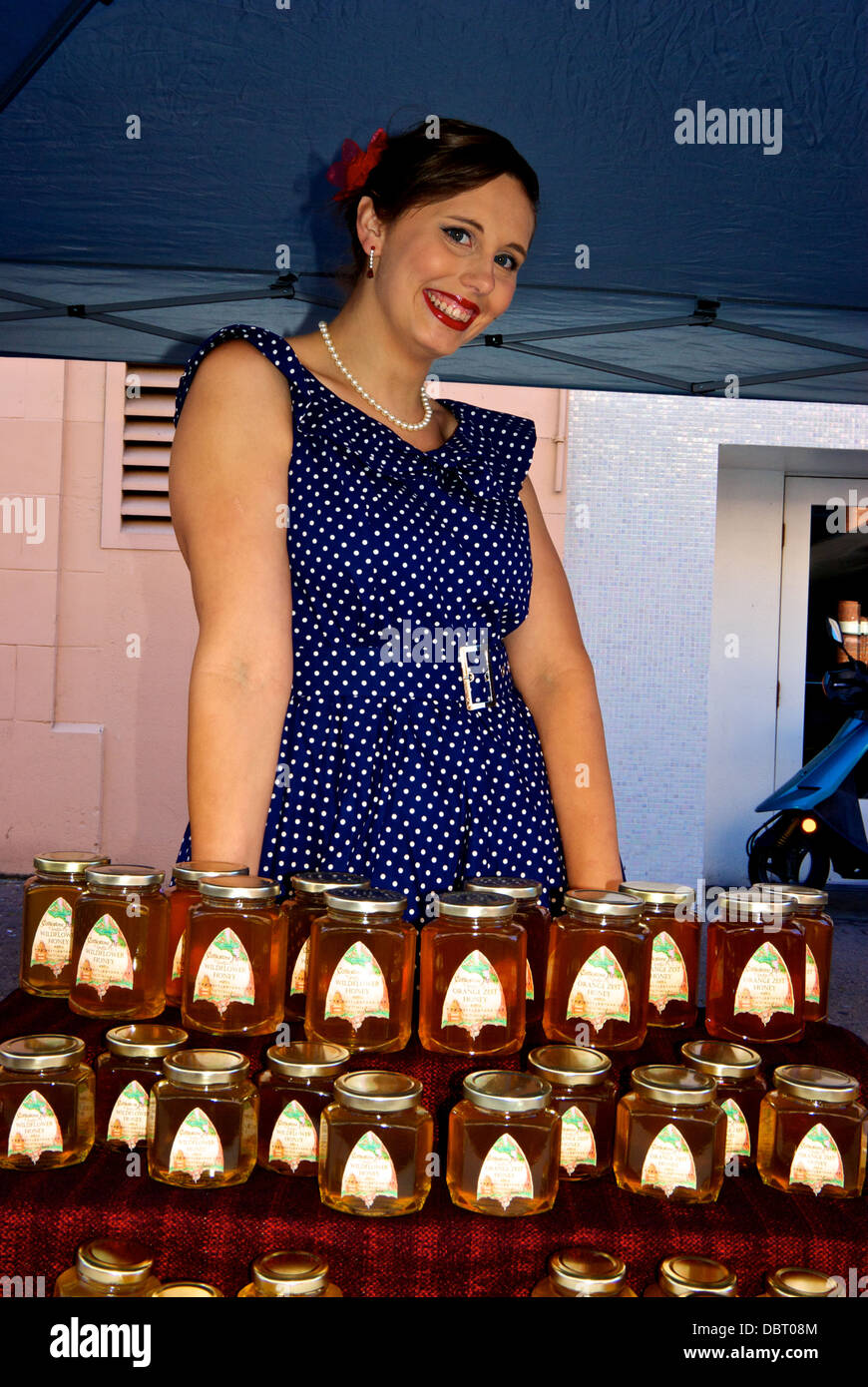 Pretty female vendor tending Cottlestone Apiary honey stand Bastion ...