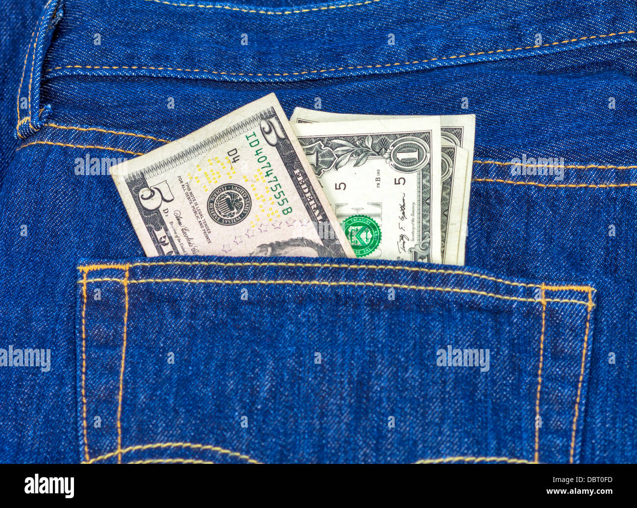 Pocket full of dollars in a pair of blue jeans Stock Photo - Alamy