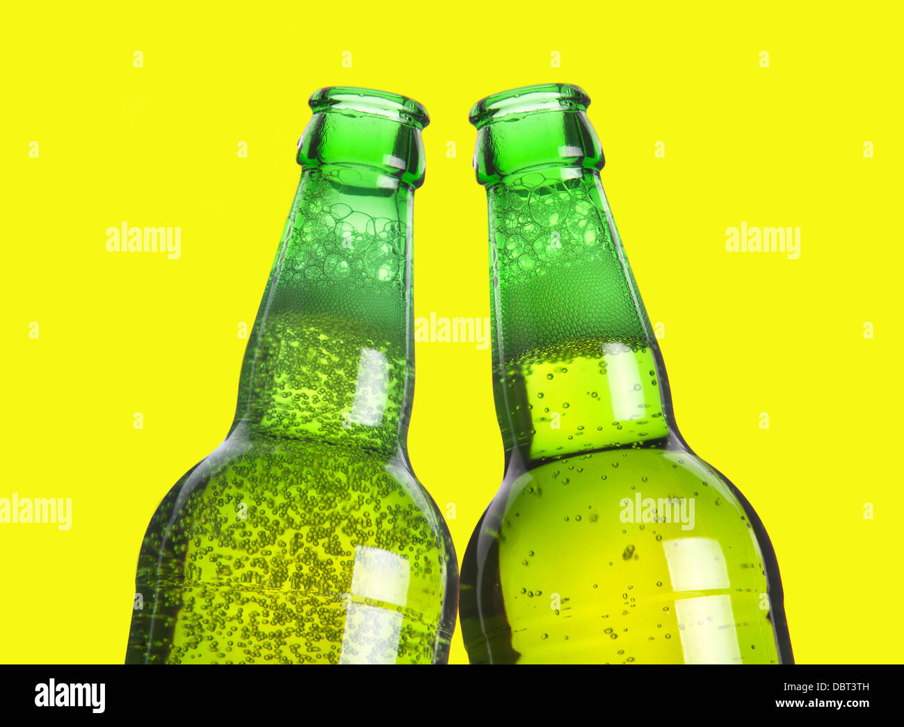 two beers making a toast on yellow backgroound Stock Photo - Alamy