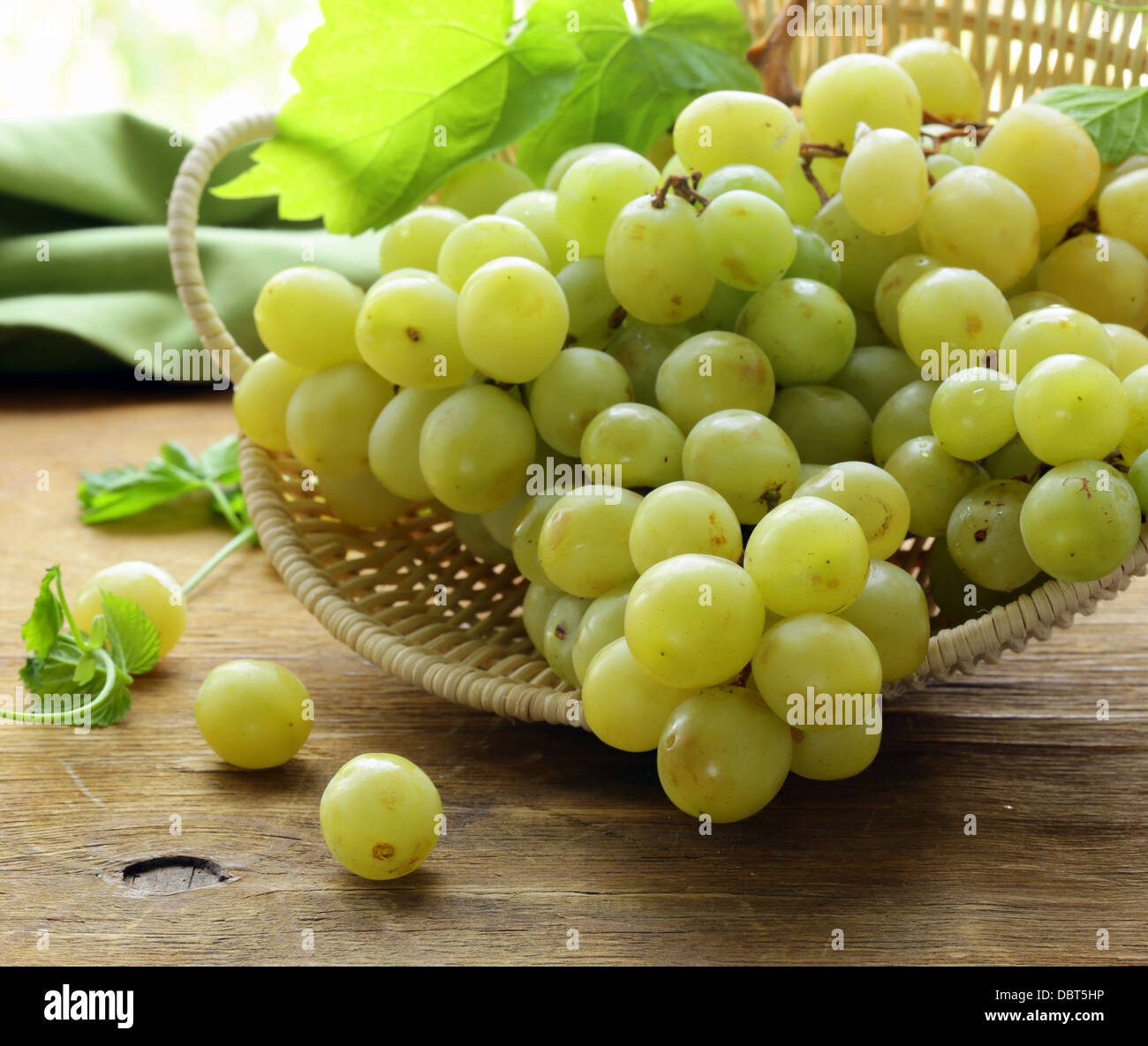 Organic white grapes in a basket on a wooden table Stock Photo - Alamy