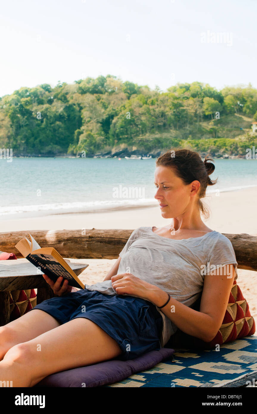 Woman reading on beach Stock Photo - Alamy