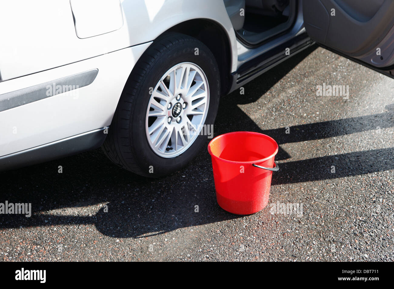 Red bucket in front of car Stock Photo - Alamy