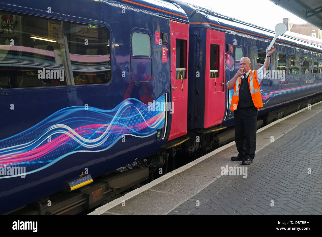 Station manager signaling train departure on Platform at Swansea ...