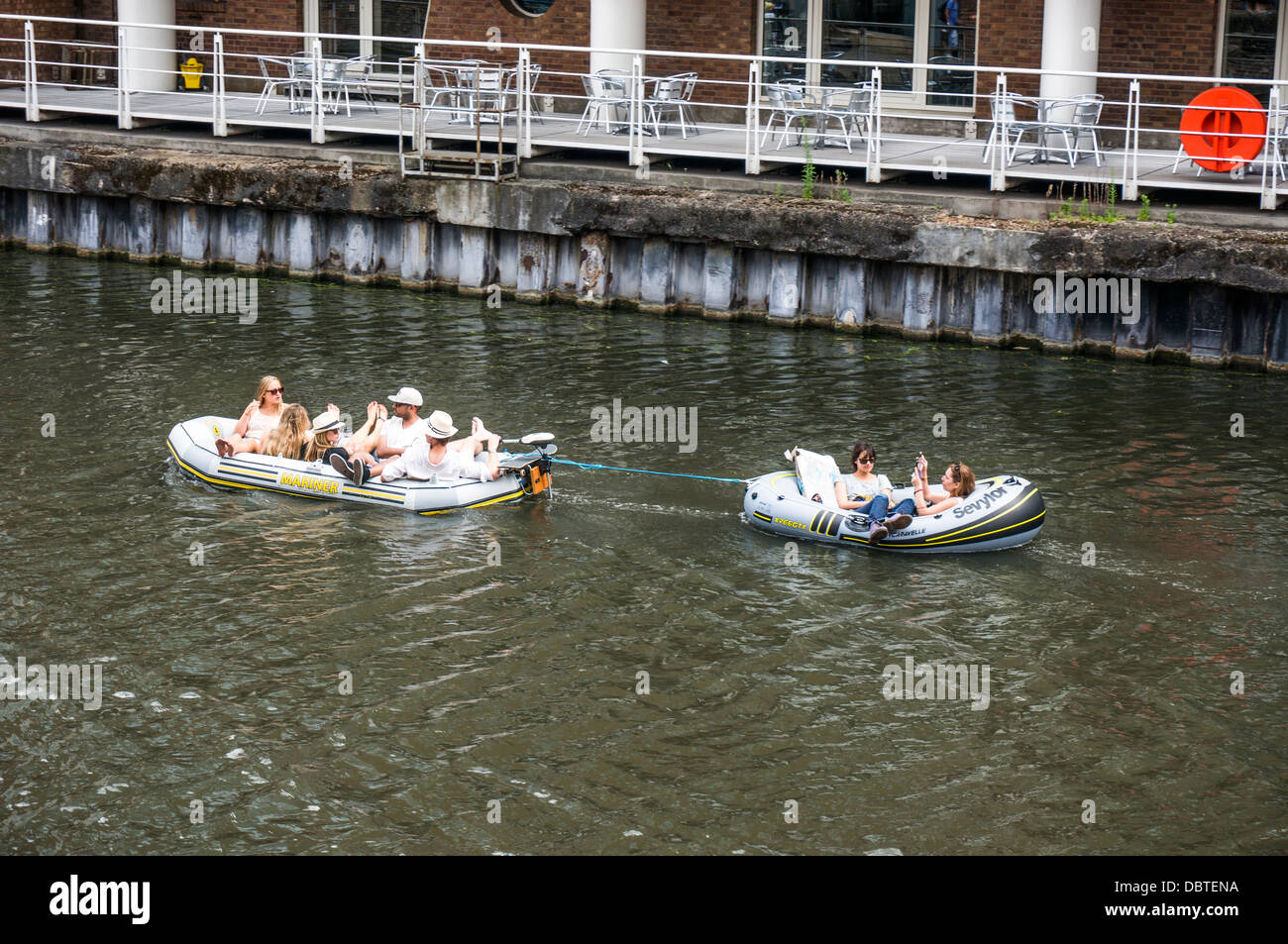 People on an inflatable boat towing other people on another inflatable ...