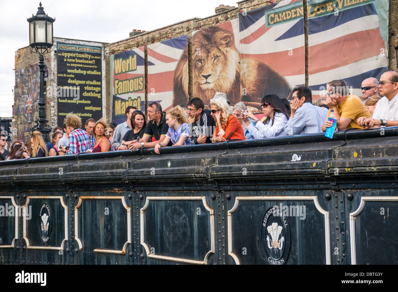 Sightseers on the Regents Canal bridge at Camden Lock, with a huge ...