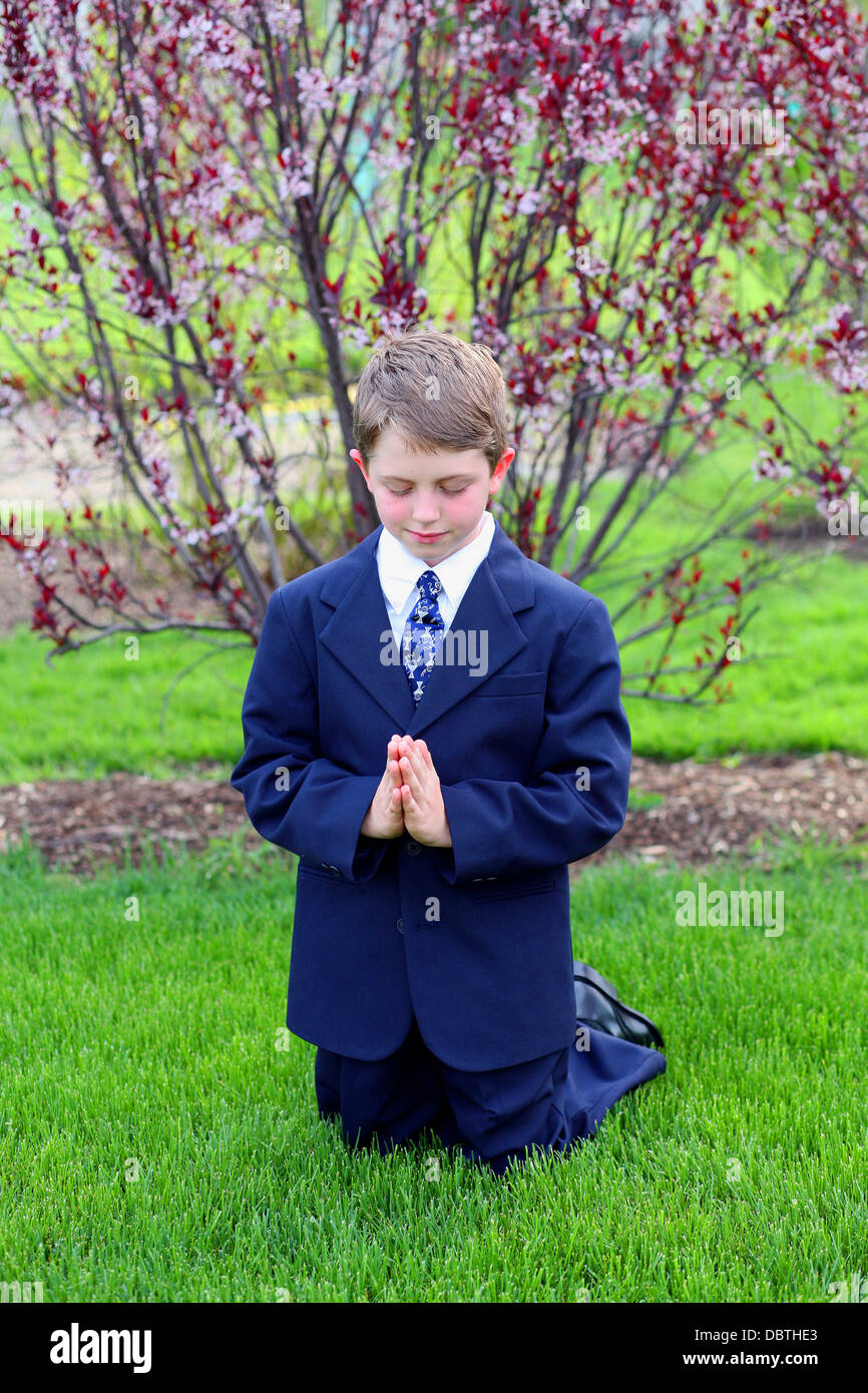 young boy in suit praying outside in grass Stock Photo - Alamy