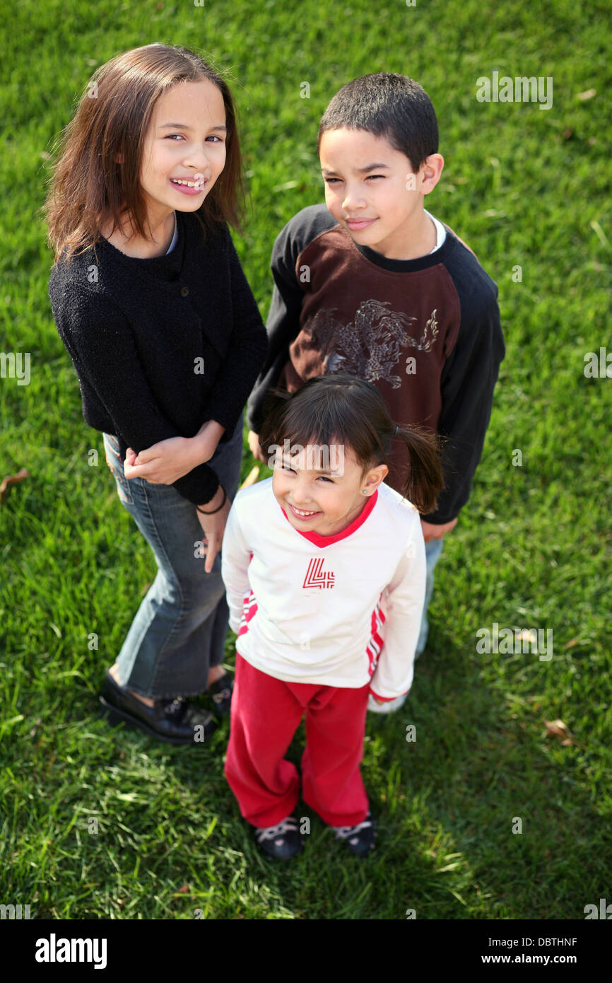 3 multi-racial kids outside in grass Stock Photo - Alamy