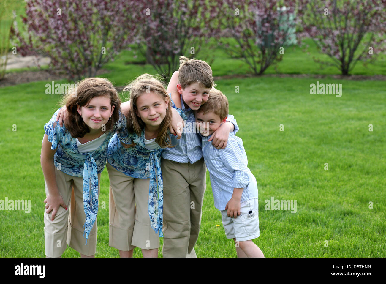 2 boys and 2 girls outside in yard smiling Stock Photo - Alamy