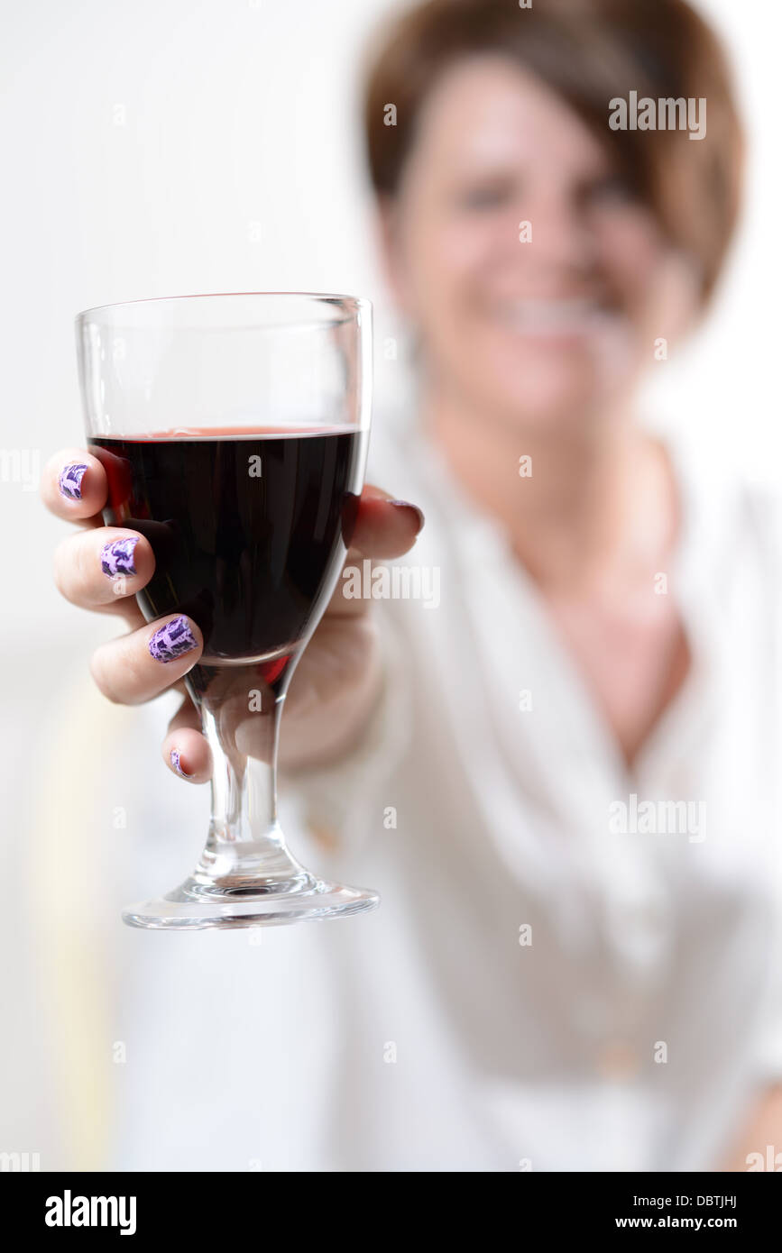 A woman offering a glass of red wine Stock Photo - Alamy