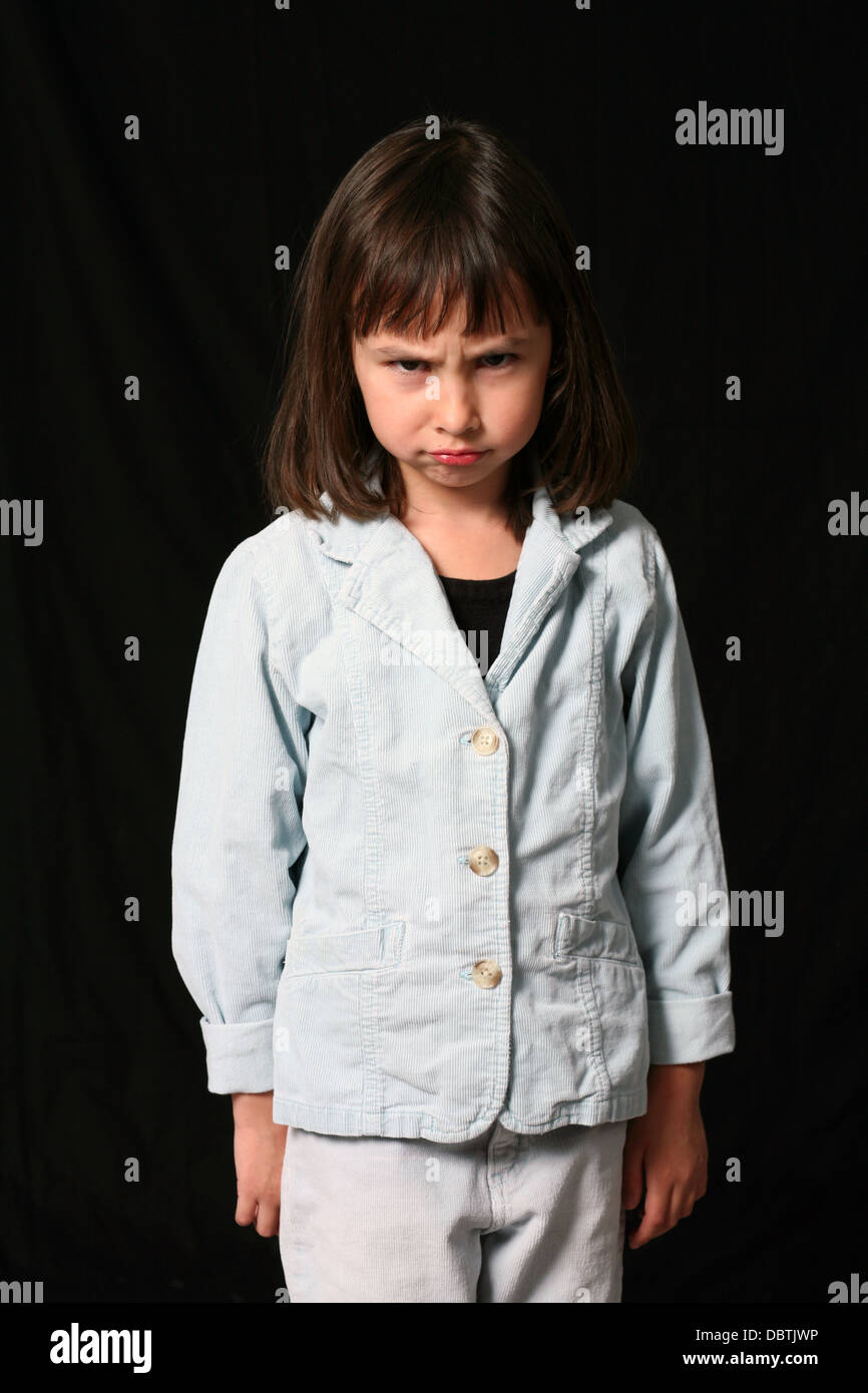 pretty little brunette girl on black background frowning Stock Photo ...