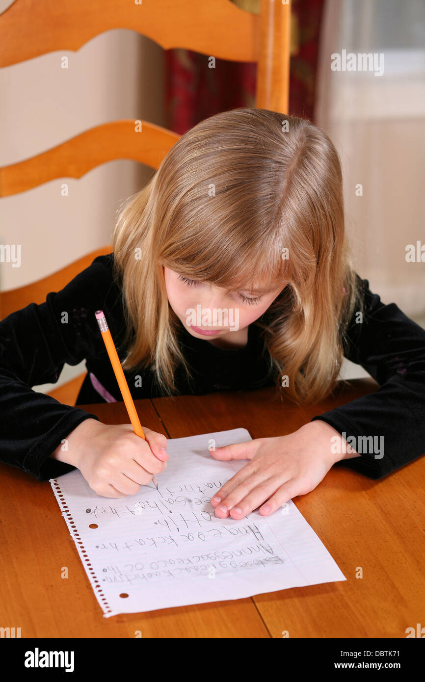 pretty little blonde girl doing homework at table Stock Photo - Alamy