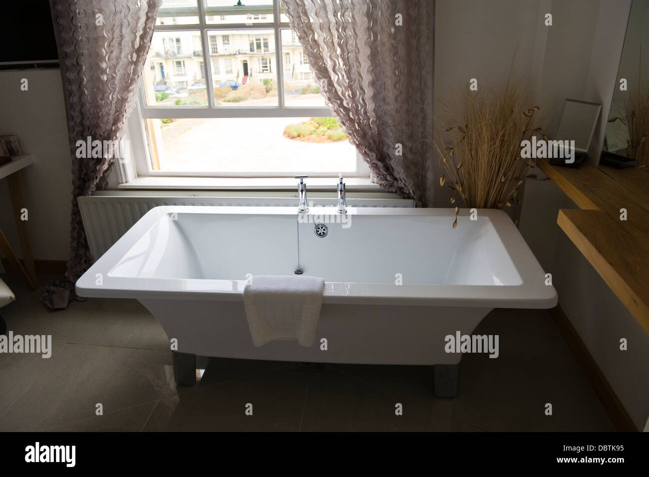 Bedroom of hotel with bath under window in Brighton East Sussex England ...