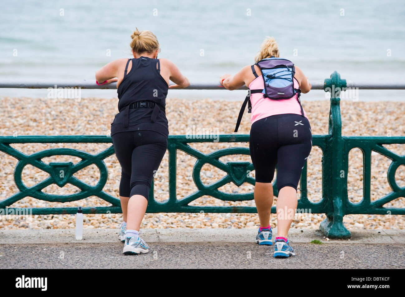 Two mature women having an early morning fitness workout on the beach ...