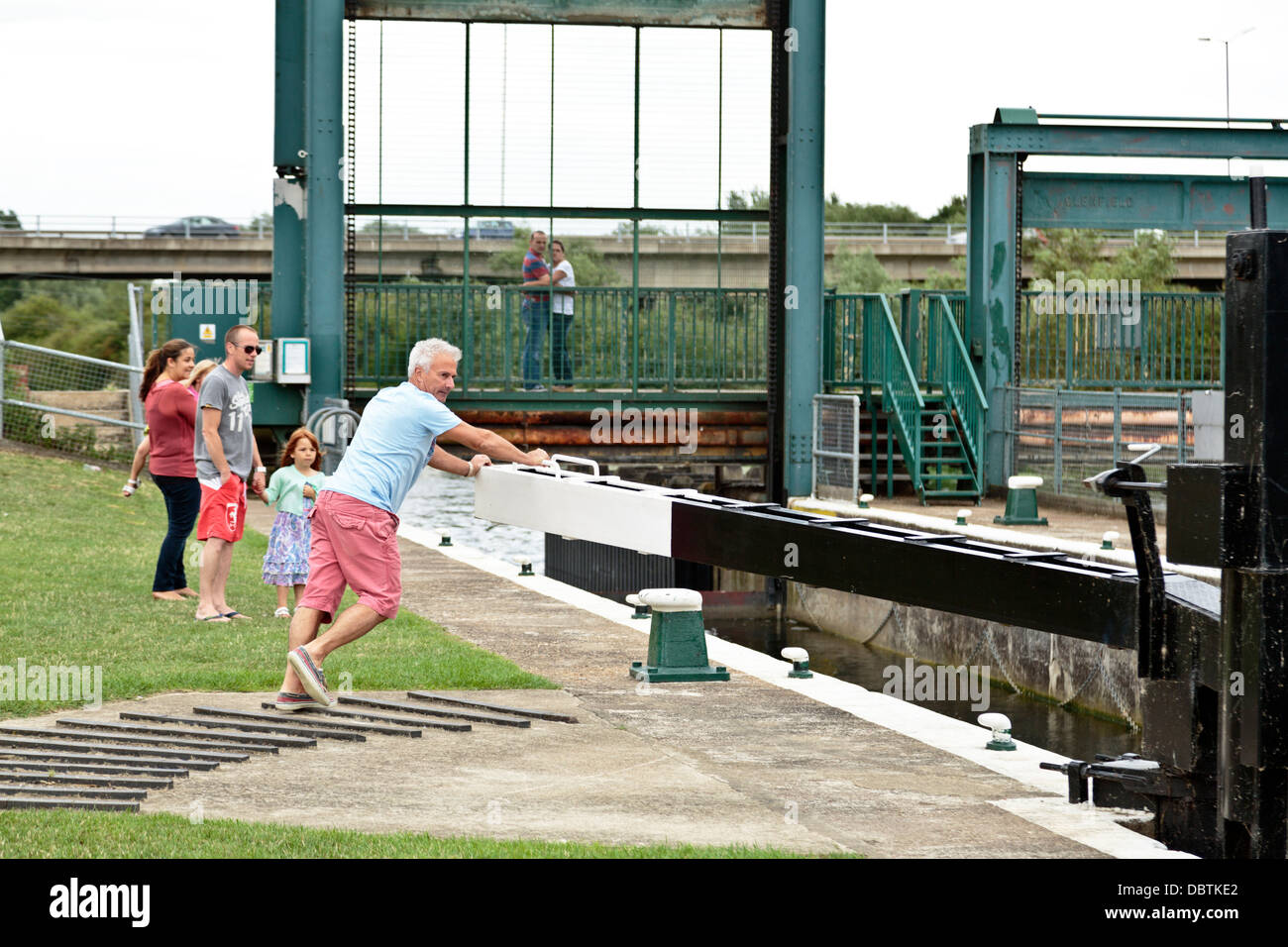 Man operating the Lock on the River Nene with people watching at Orton ...
