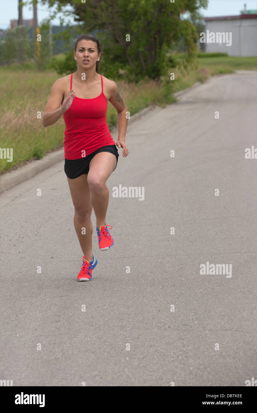 Woman running alone on road hi-res stock photography and images - Alamy