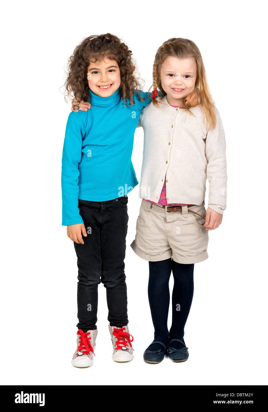 Two young girls posing isolated in white Stock Photo - Alamy