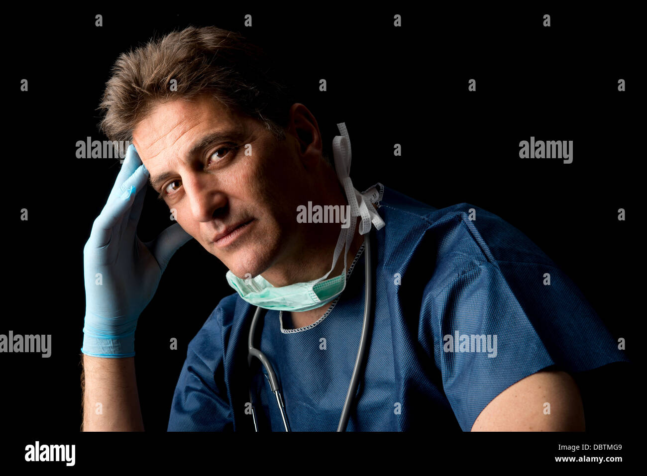 Tired doctor in uniform isolated against a black background Stock Photo ...