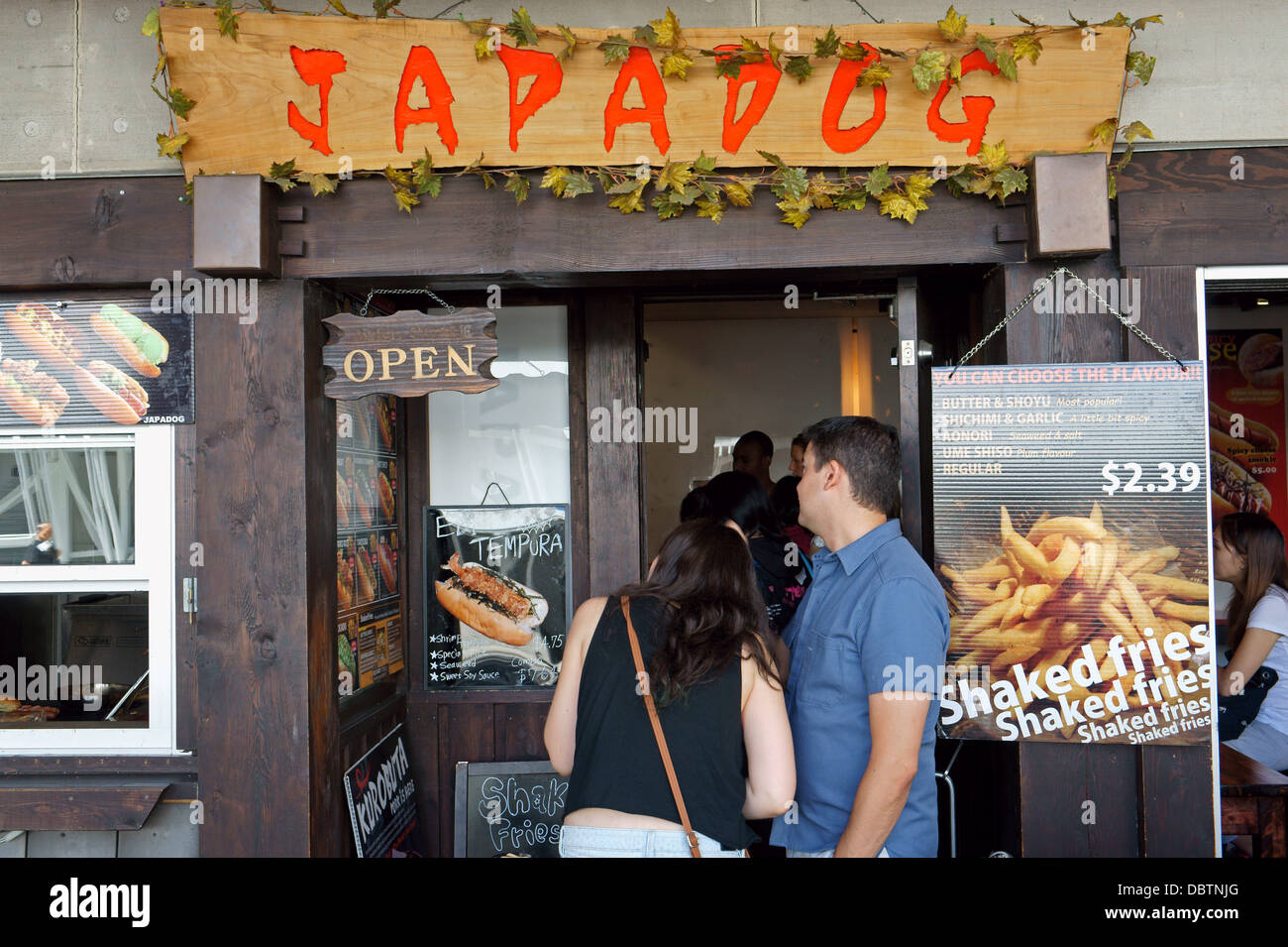 Asian couple looking at the menu at Japadog Japanese style hotdog ...