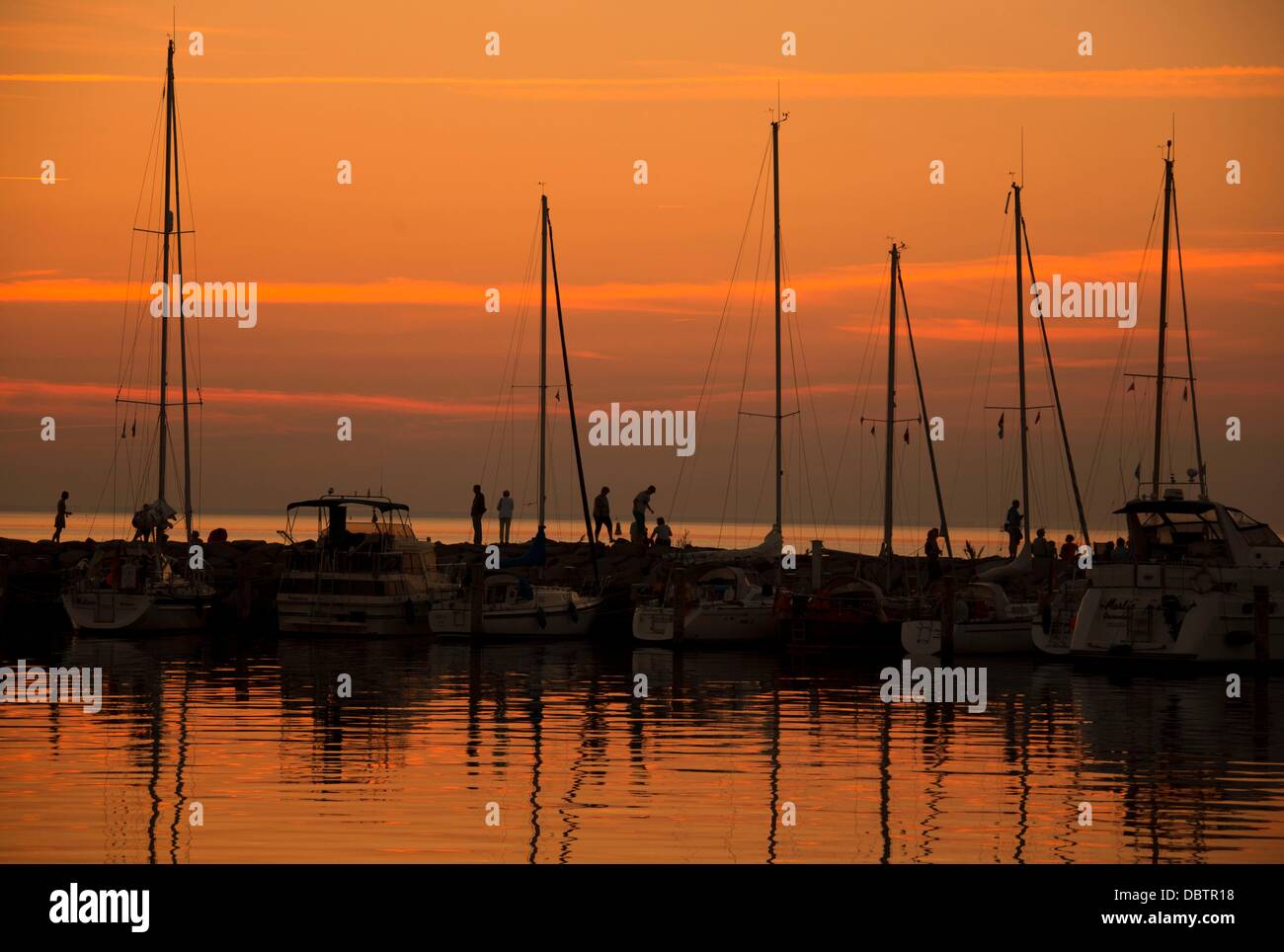 The sky is turned red by the sinking sun at the harbour of Timmendorf ...