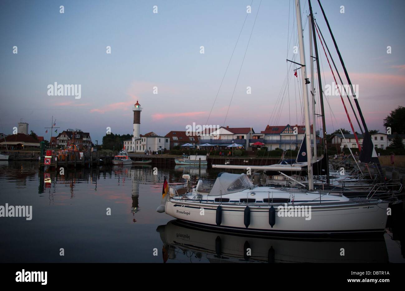 Sailing vessels are moored at the harbour of Timmendorf after sunset on ...