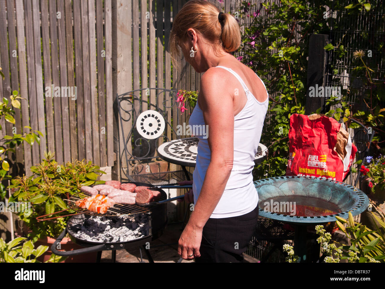 Woman Cooking Food On A barbeque Stock Photo - Alamy