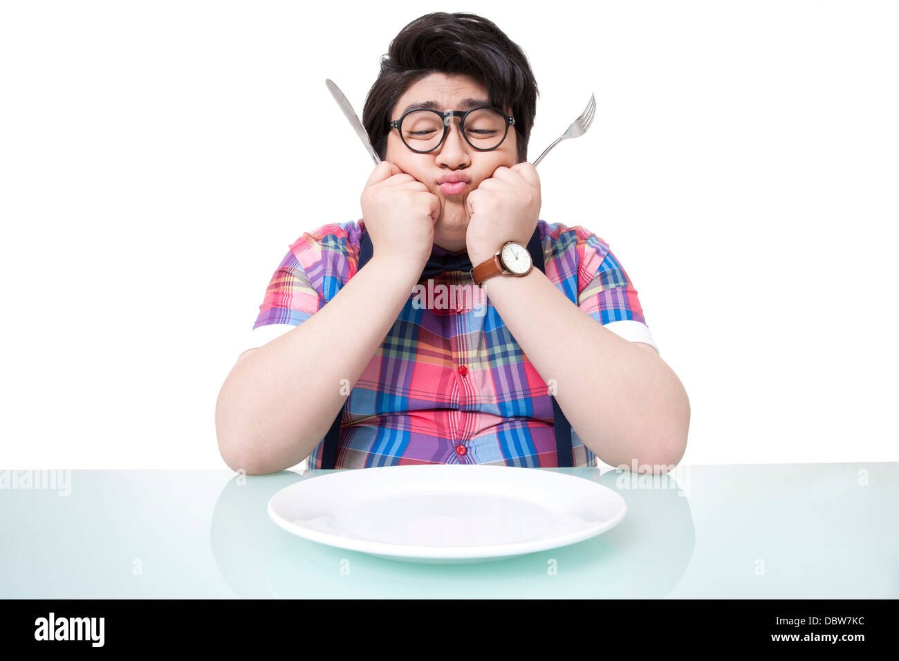 Worried overweight young man looking at empty plate Stock Photo - Alamy