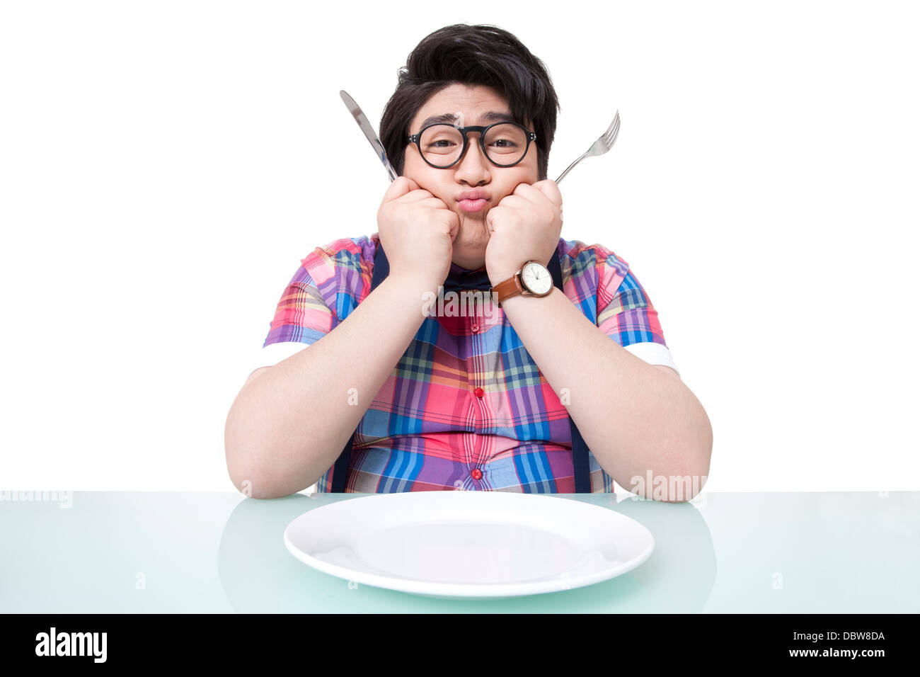 Worried overweight young man with empty plate Stock Photo - Alamy