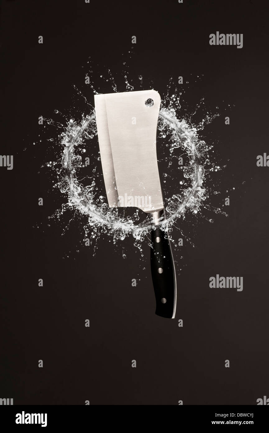 Metal cleaver suspended in air with splashing ring of water Stock Photo ...