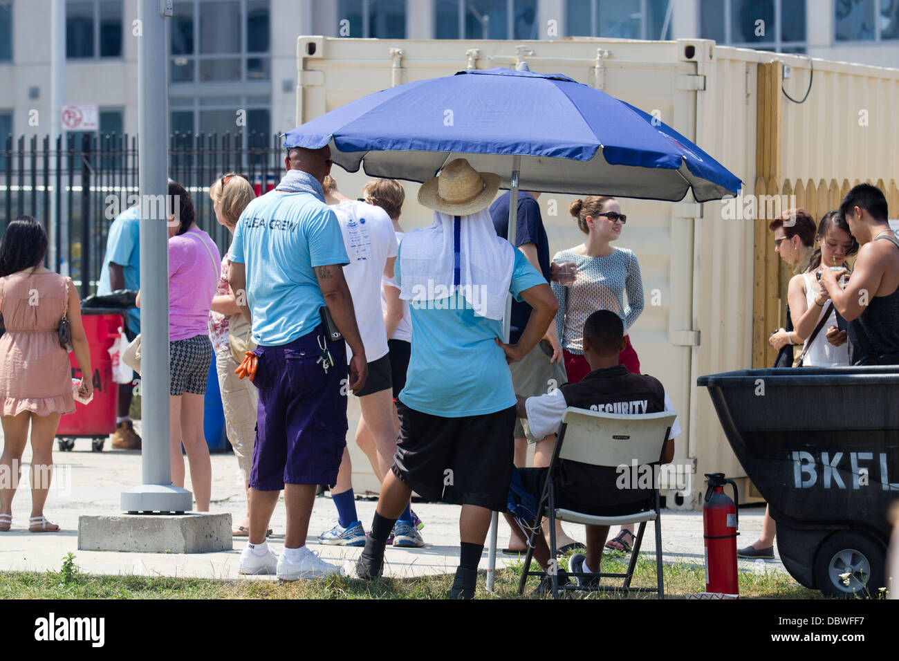 People under umbrella for shade Stock Photo - Alamy