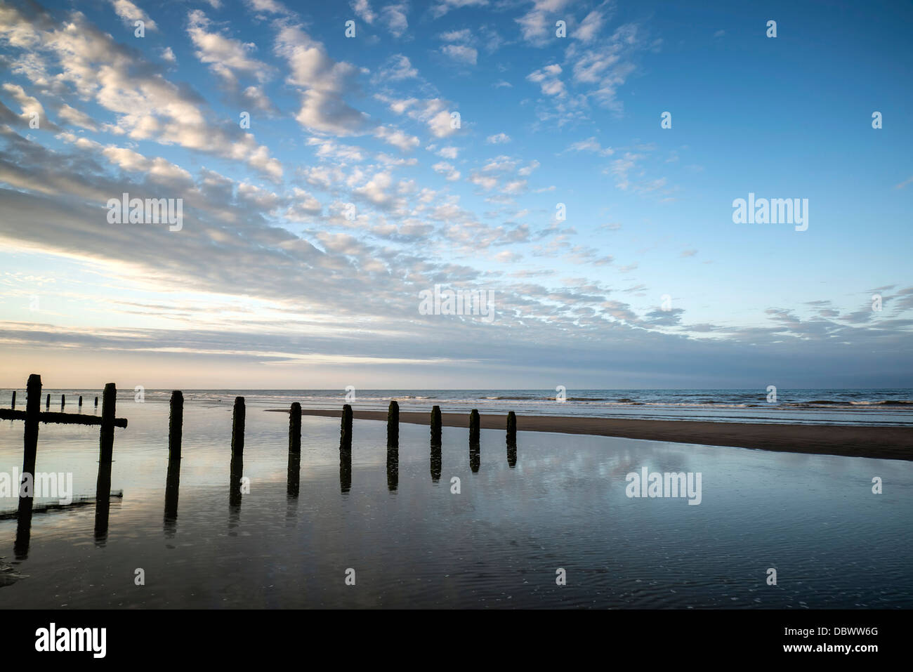 Beautiful sunrise reflected in low tide water pools on beach landscape ...