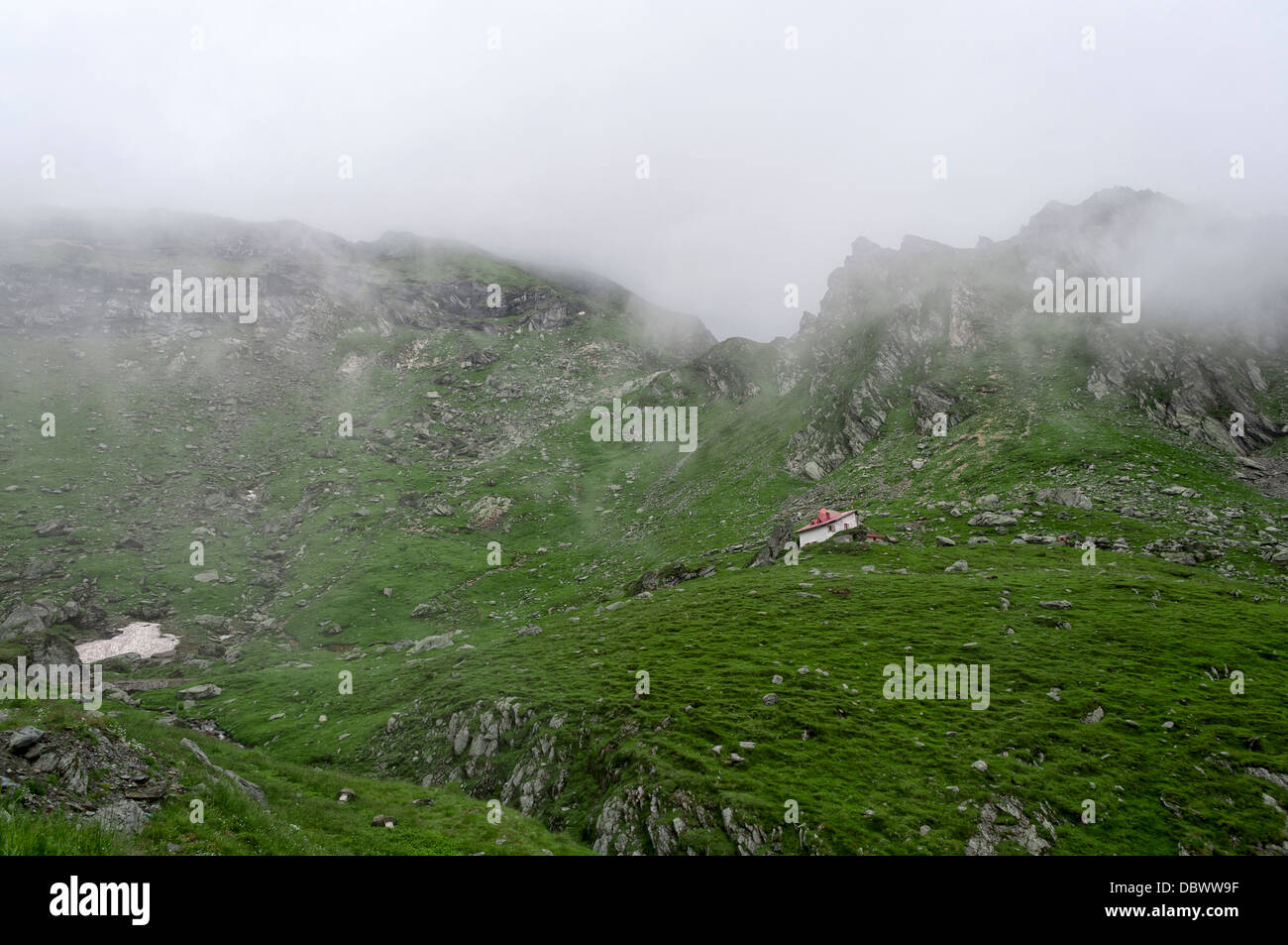 Morning mountain landscape with fog and a small building Stock Photo ...