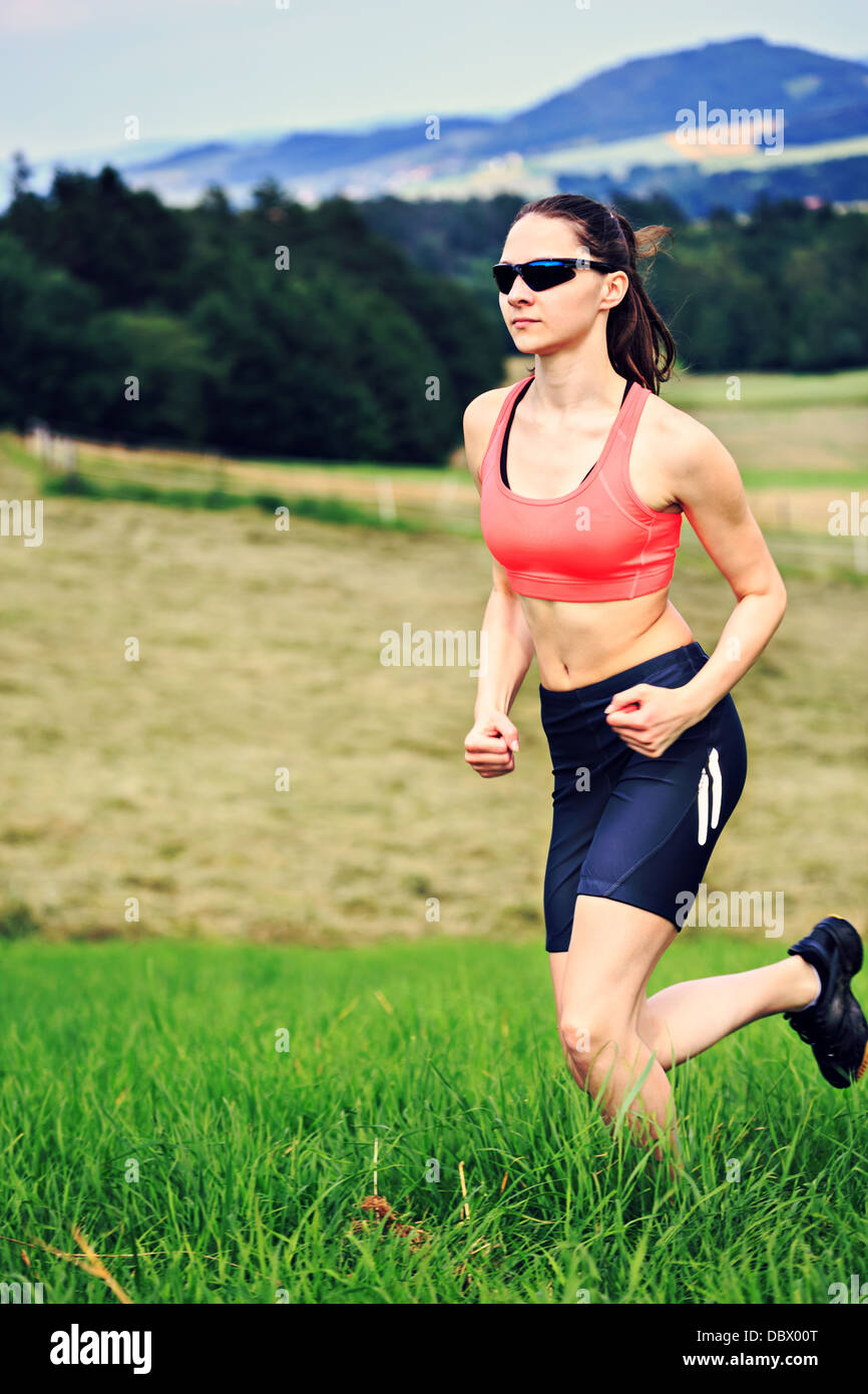 young woman jogging in front of cross country Stock Photo - Alamy