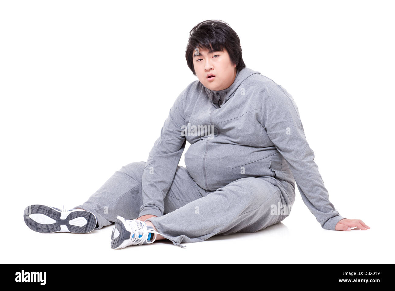 Overweight man sitting on floor Stock Photo - Alamy