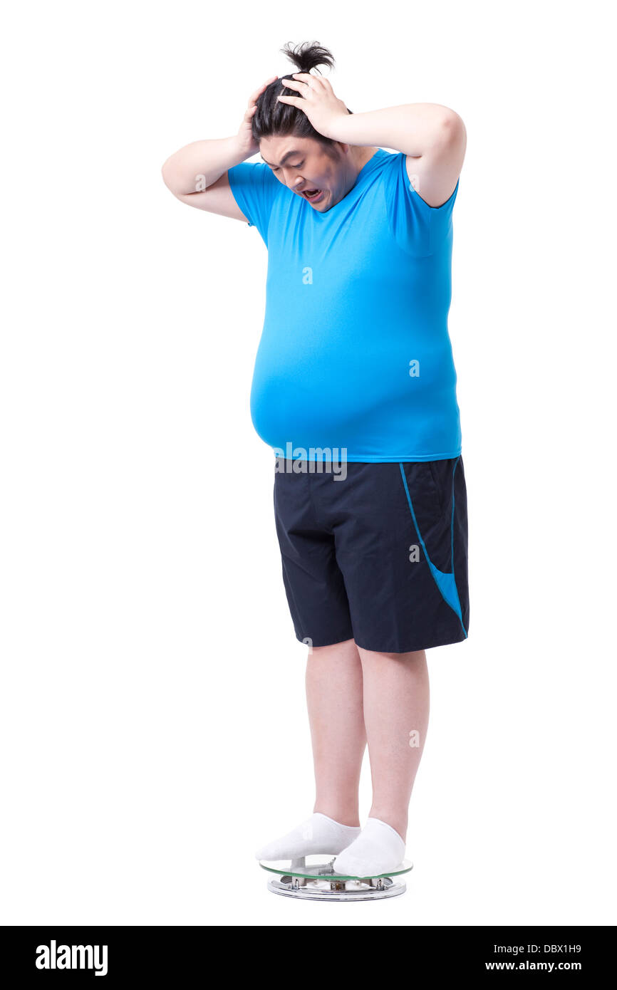 Overweight man on scale, shocked Stock Photo - Alamy
