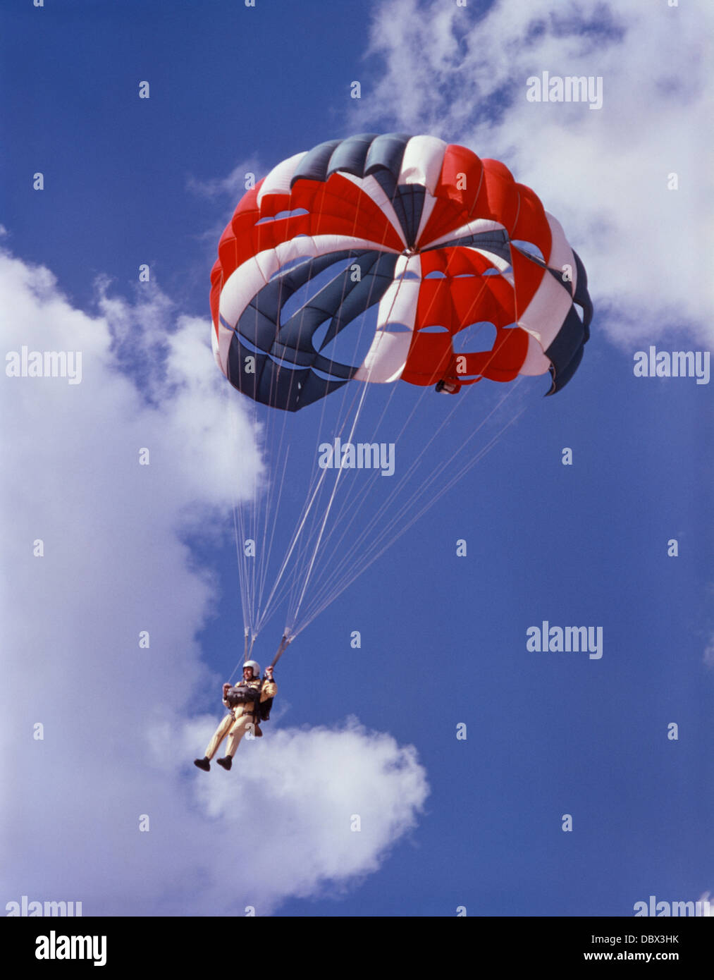 1970s PARACHUTIST IN SKY RED WHITE BLUE PARACHUTE YELLOW JUMPSUIT Stock ...