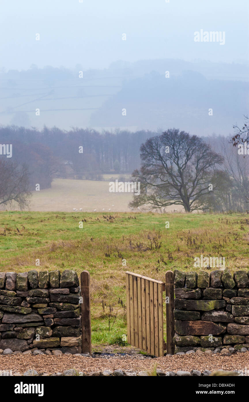 Dry stone wall with wooden gate - ajar Stock Photo - Alamy