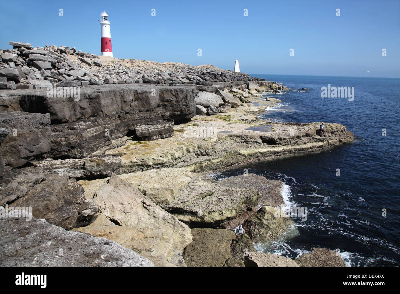 The lighthouse at Portland Bill with the famous stone cliffs in the ...