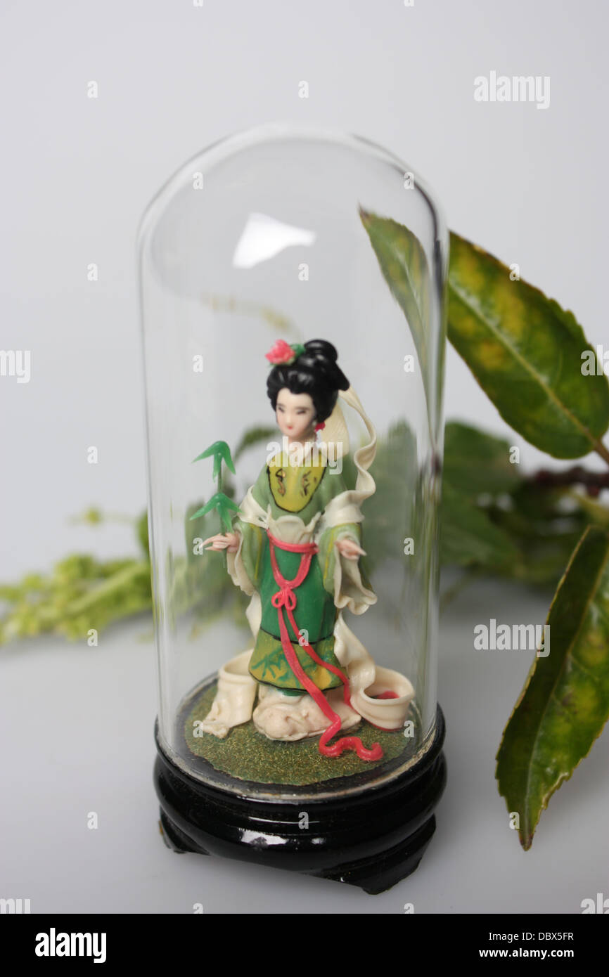 A glass figure holding a Chinese lady tourist object within glass ...
