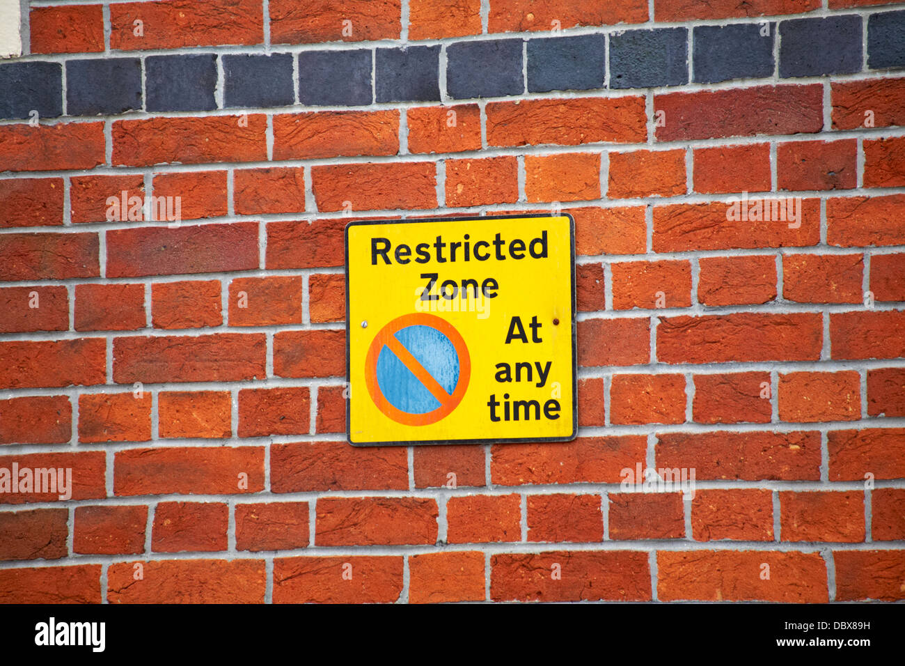 Restricted zone no parking at any time sign on brick wall at Weymouth ...