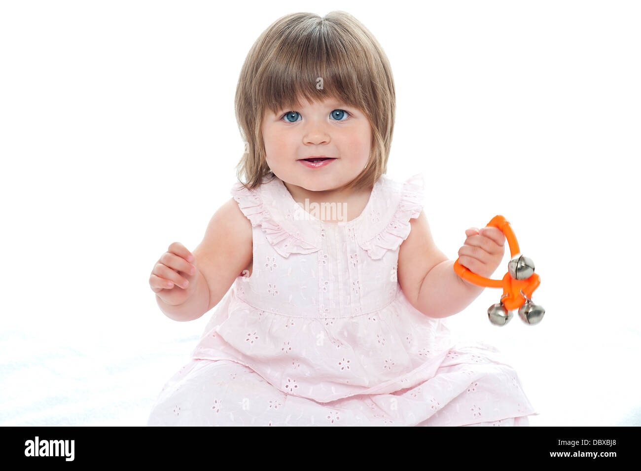 Healthy baby girl sitting on floor playing with rattle Stock Photo - Alamy