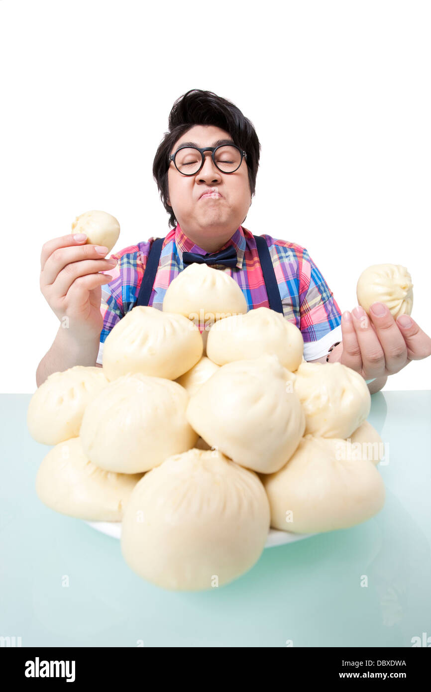 Overweight young man eating steamed stuffed buns Stock Photo - Alamy