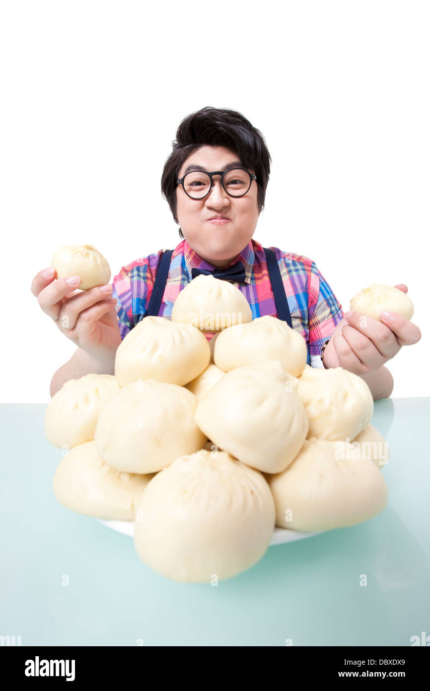 Overweight young man eating steamed stuffed buns Stock Photo - Alamy