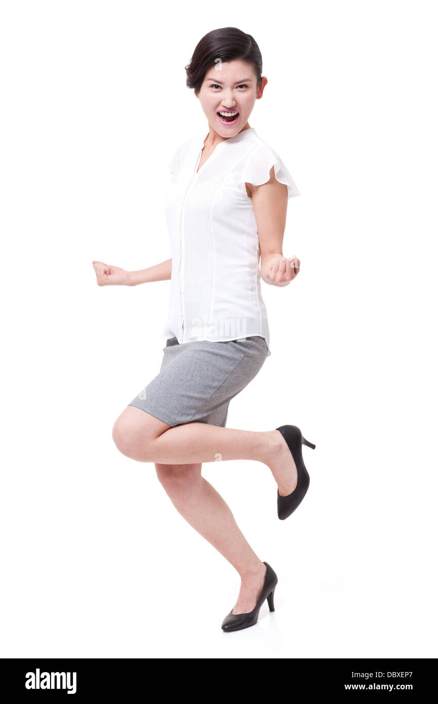 Excited businesswoman standing on one leg Stock Photo - Alamy