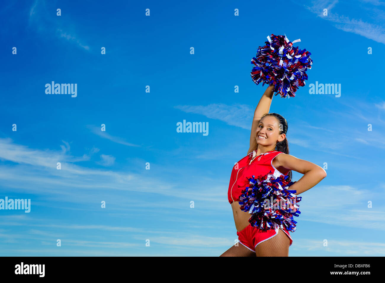 Young cheerleader in red costume with pampon Stock Photo - Alamy