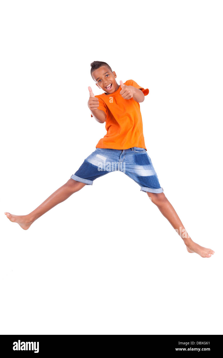 Portrait of a cute teenage black boy jumping over white background ...